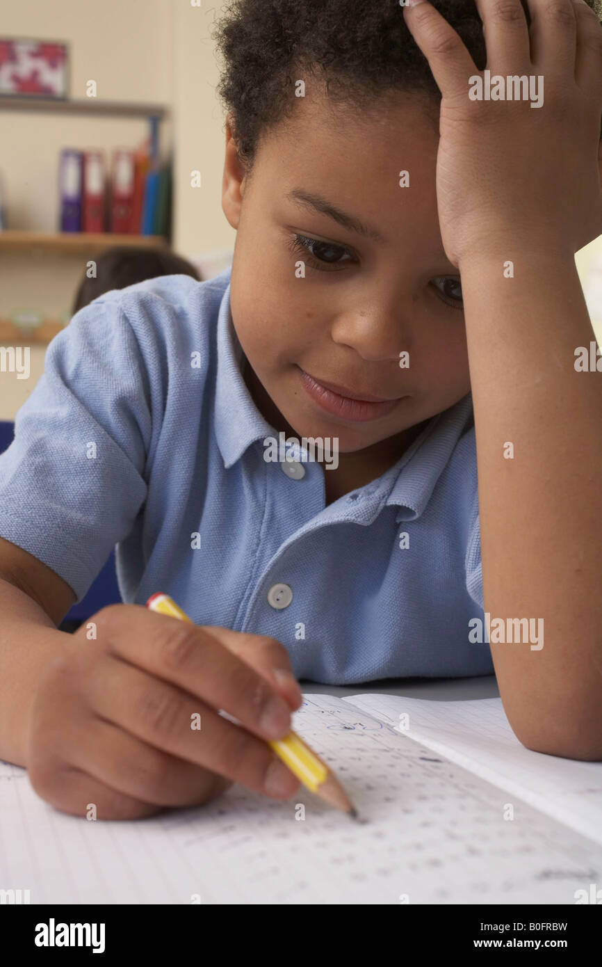 Boy writing in classroom Stock Photo - Alamy