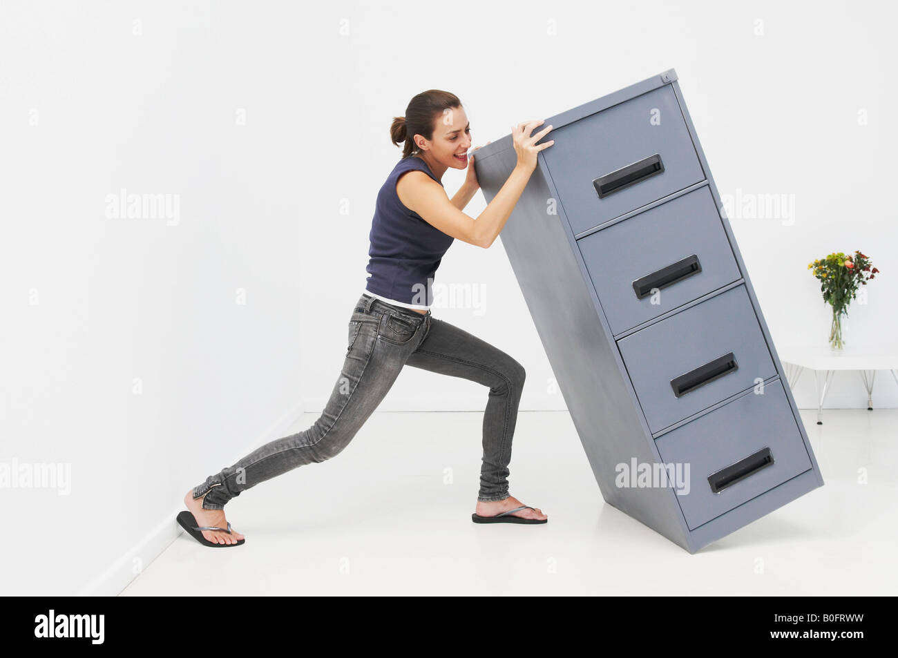 Woman struggles with filing cabinet Stock Photo - Alamy