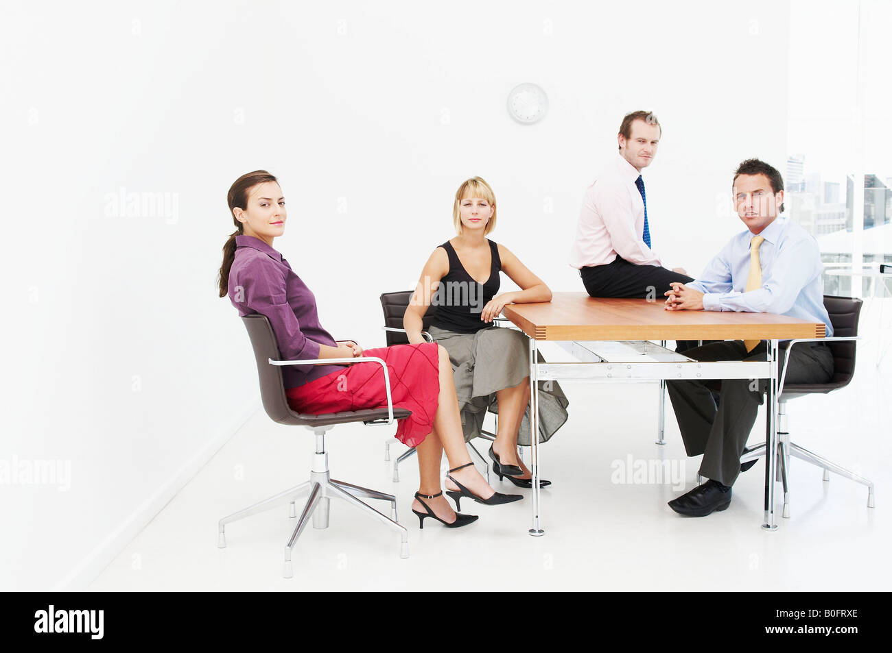 Seated business people look to camera Stock Photo - Alamy