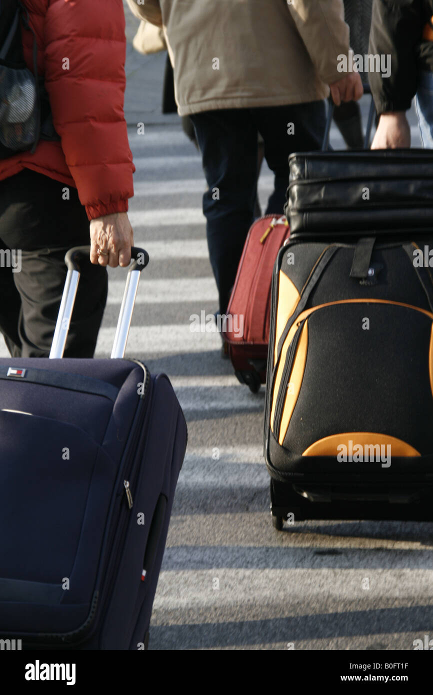 people pulling trolley cases in town Stock Photo - Alamy