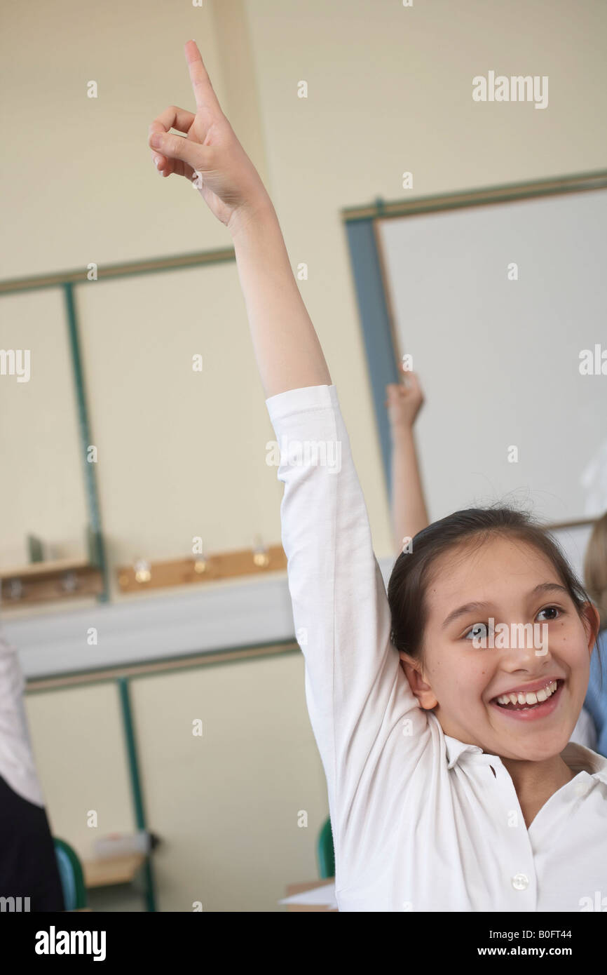 Girl raising her hand in classroom Stock Photo - Alamy