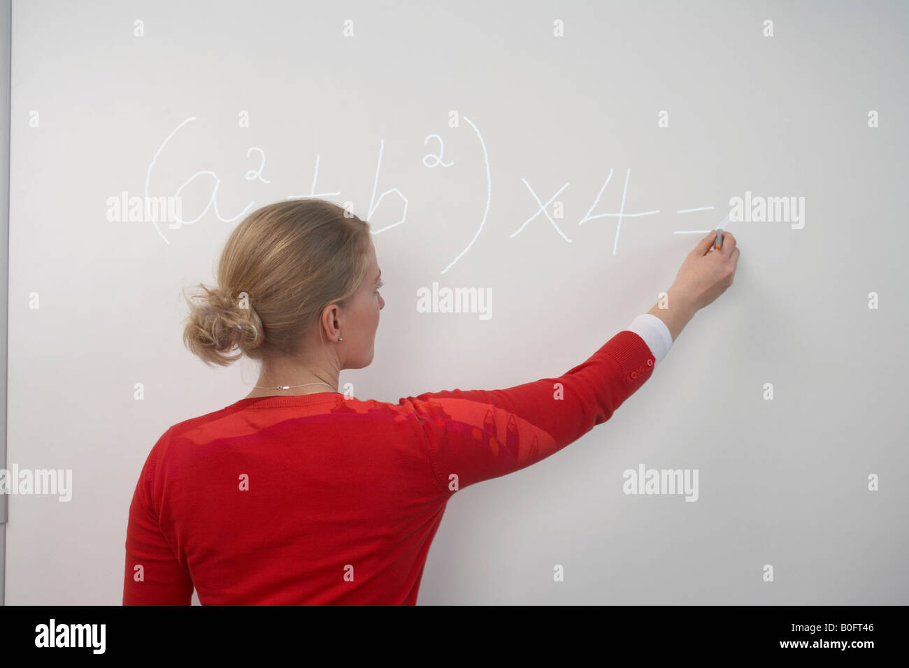 Teacher writing on whiteboard Stock Photo - Alamy