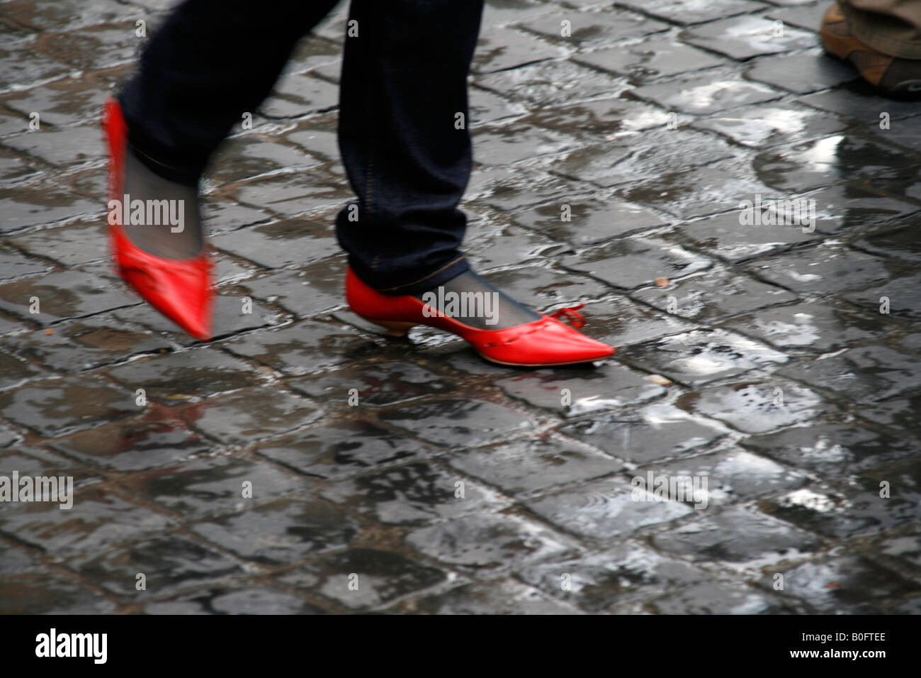 woman wearing red shoes walking in town Stock Photo - Alamy
