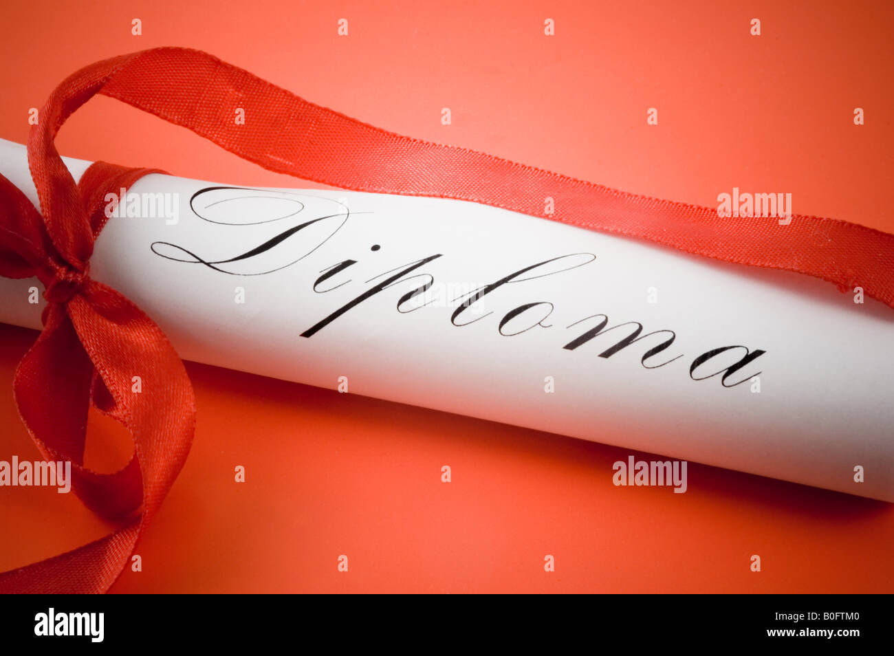 Diploma with red ribbon on red background Stock Photo - Alamy