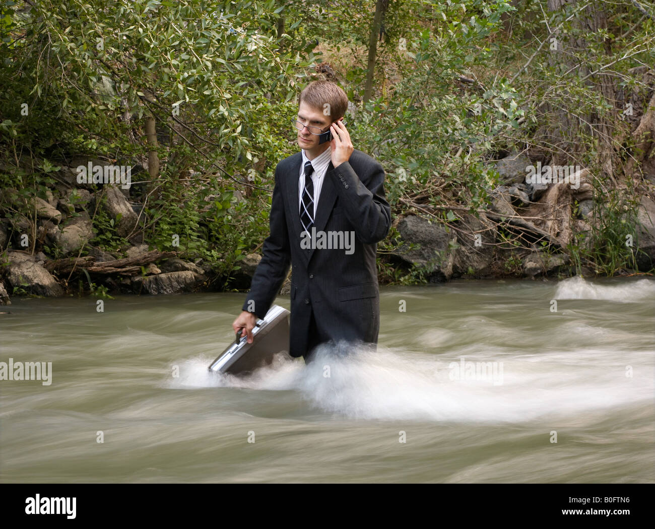 businessman in suit on phone wading upstream in a river Stock Photo - Alamy