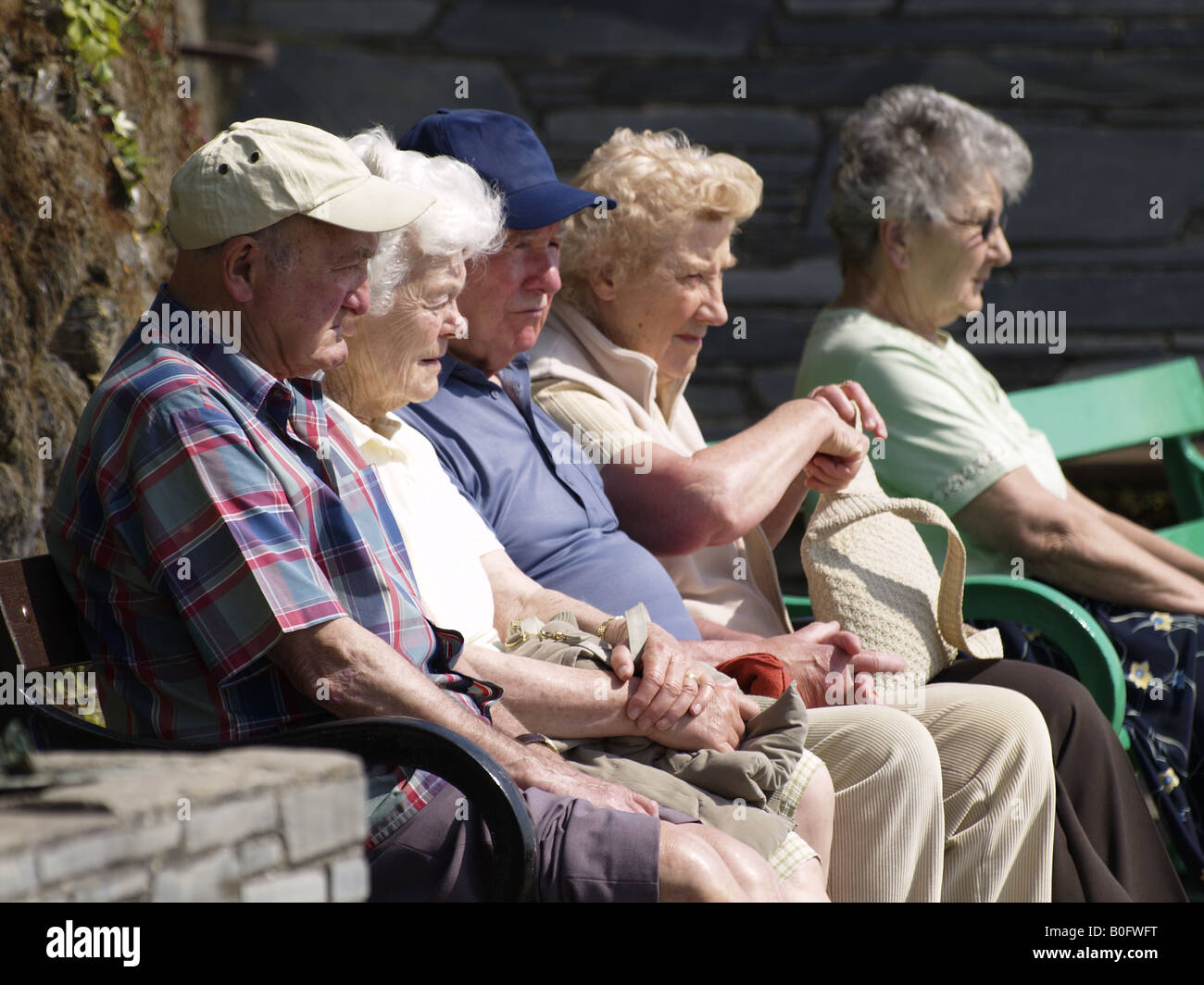 Old people sat on a bench enjoying the sunshine Stock Photo - Alamy