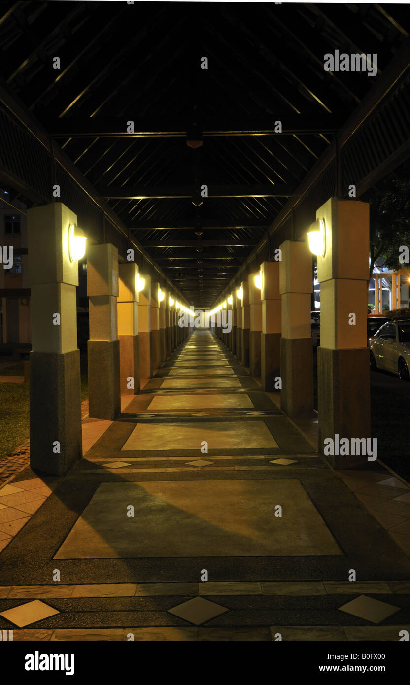 Covered and lit walkway in a Singapore public housing estate at night ...