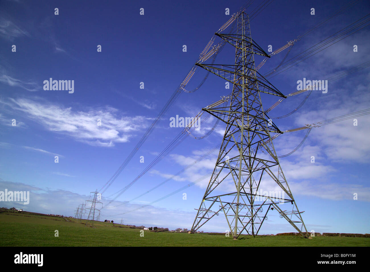 Electricity pylons against a blue sky with white clouds Stock Photo - Alamy
