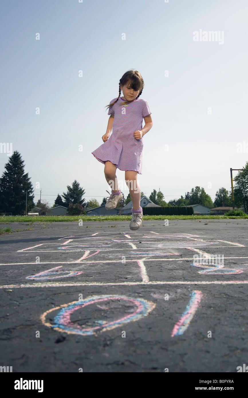 Young girl playing hopscotch in schoolyard Stock Photo - Alamy