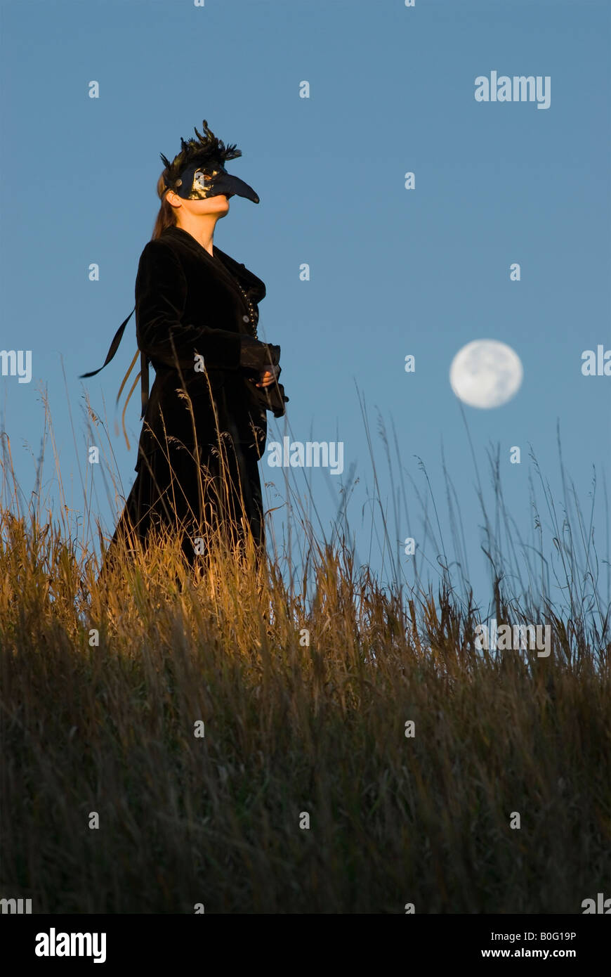 A masked woman in a black velvet dress poses as a Crow or Raven Spirit ...