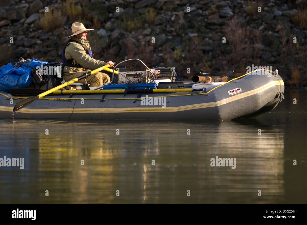 Man rows a raft on the Salmon River in Idaho with reflection in ...