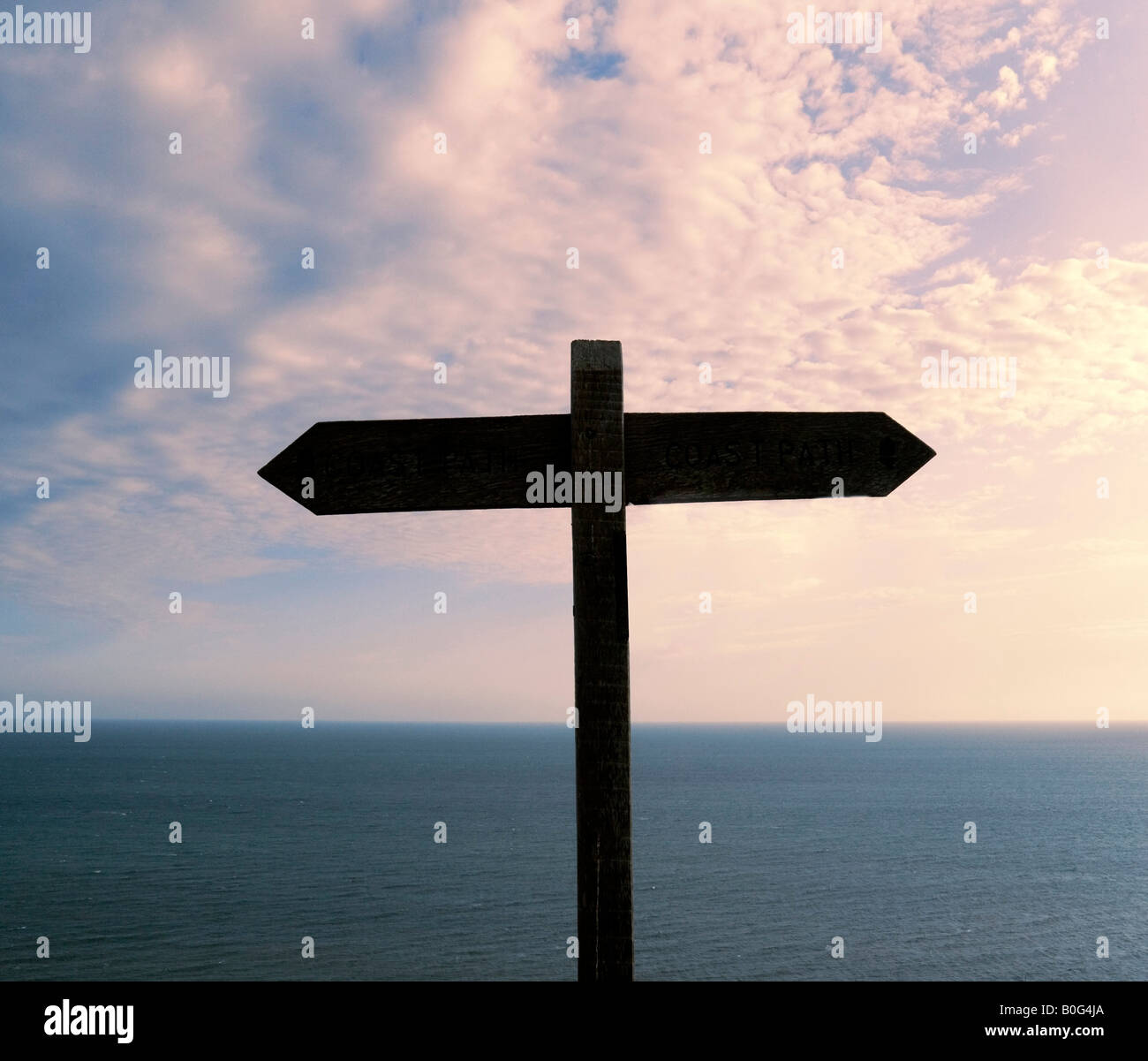 signpost with background of sunset sky and sea room for text to be ...