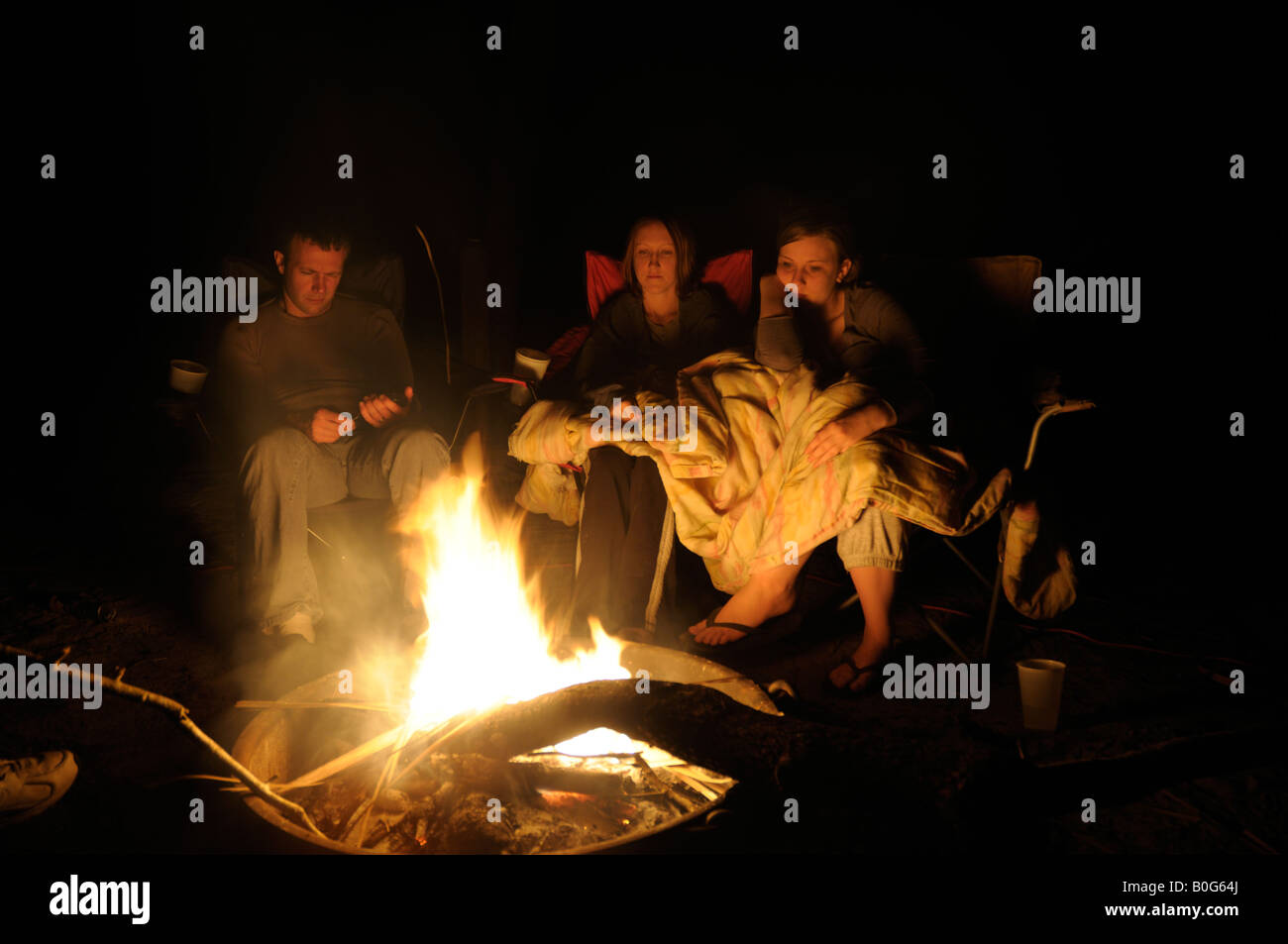 Vacationers sitting around a campfire on Hunting Island in South ...