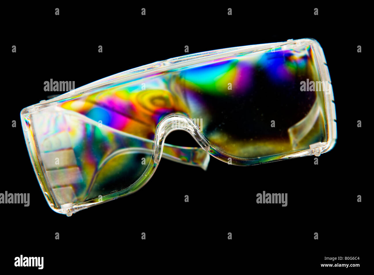 Polarised safety glasses showing rainbow stress markings. On black ...