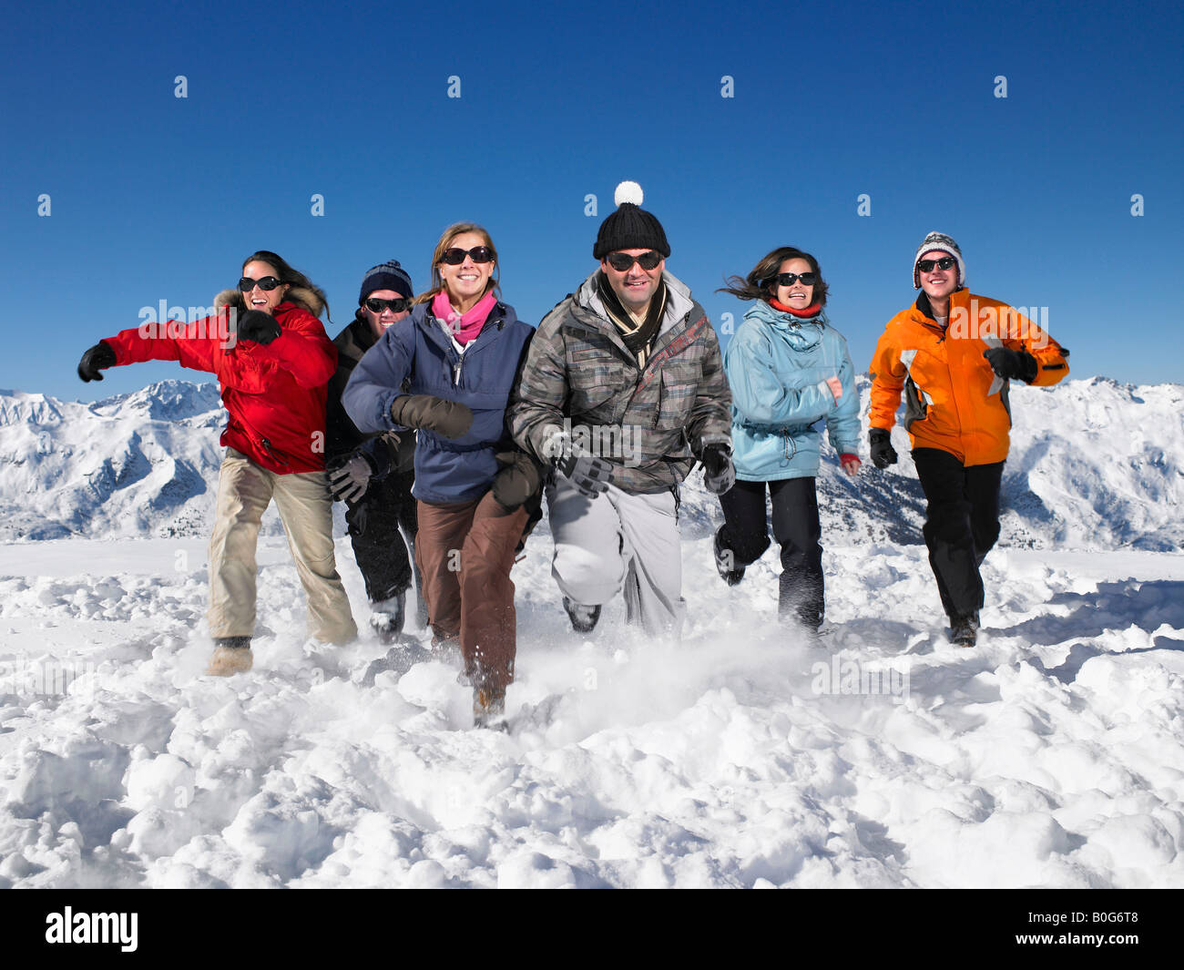 Group running in snow Stock Photo - Alamy