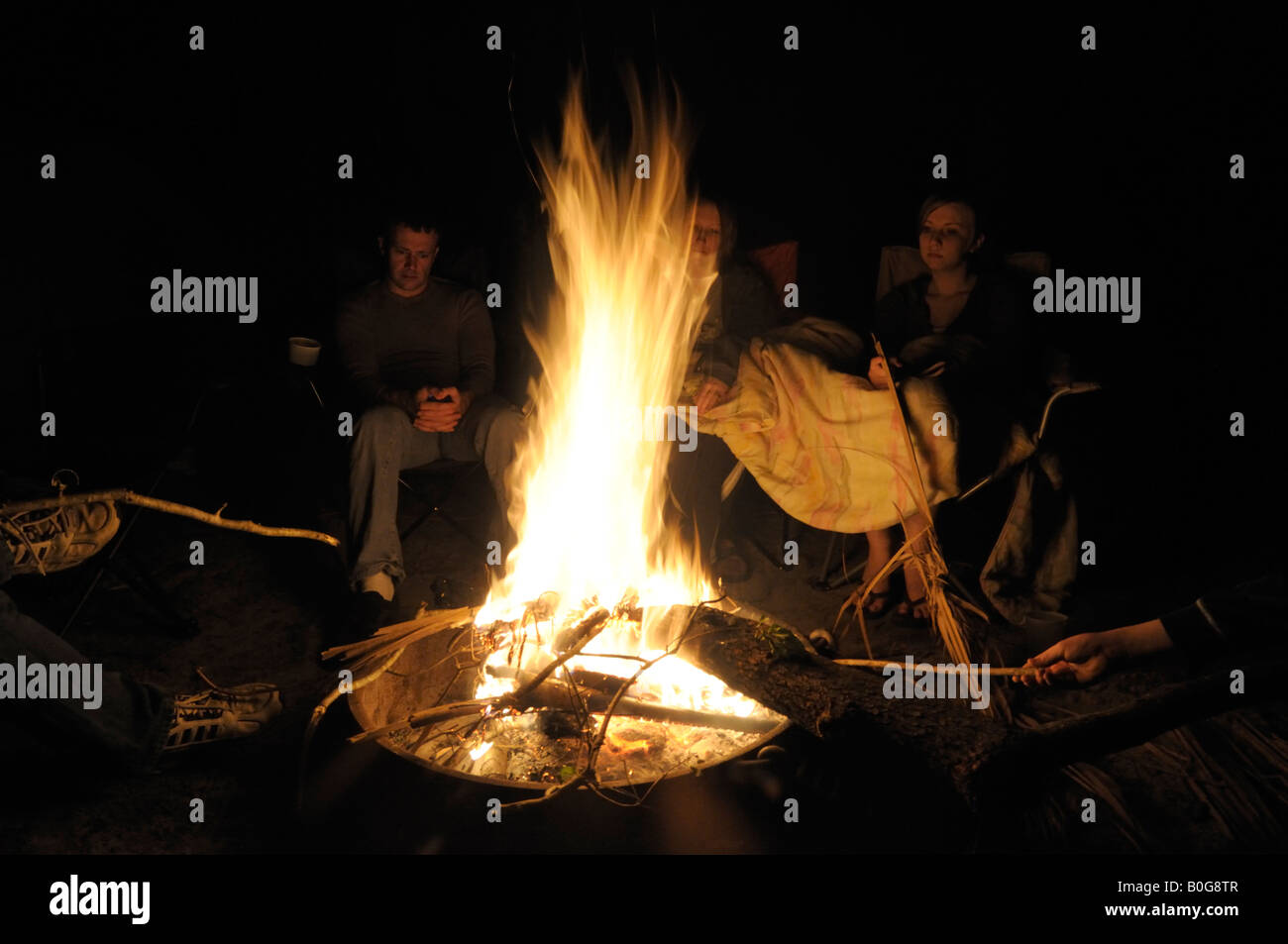 Friends sitting around a fire hi-res stock photography and images - Alamy