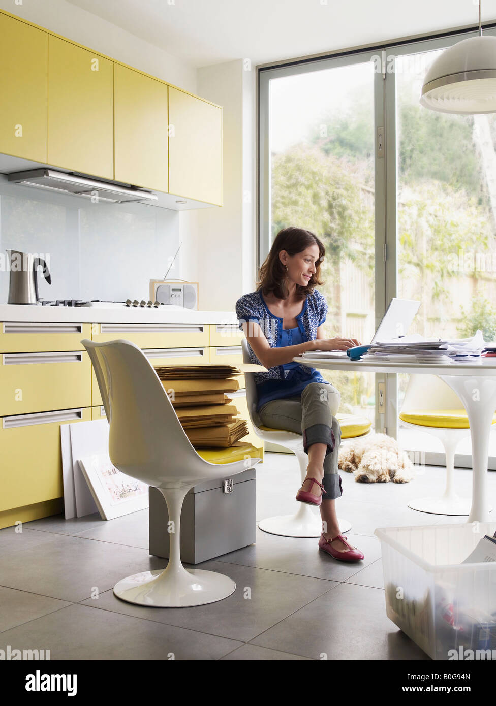 Woman running business at kitchen table Stock Photo - Alamy