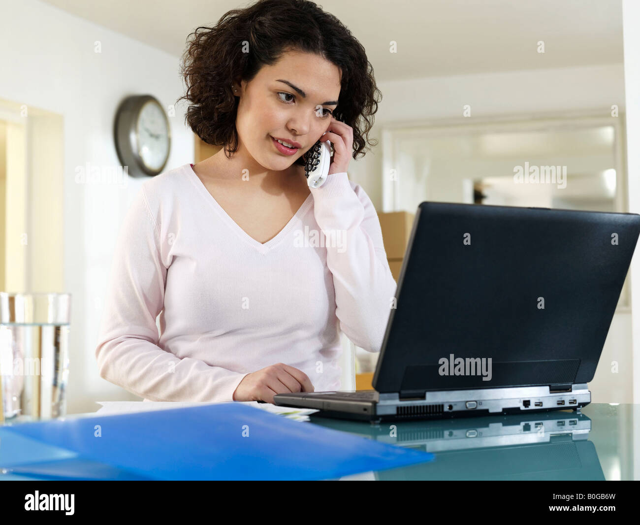 Woman on phone with laptop Stock Photo - Alamy