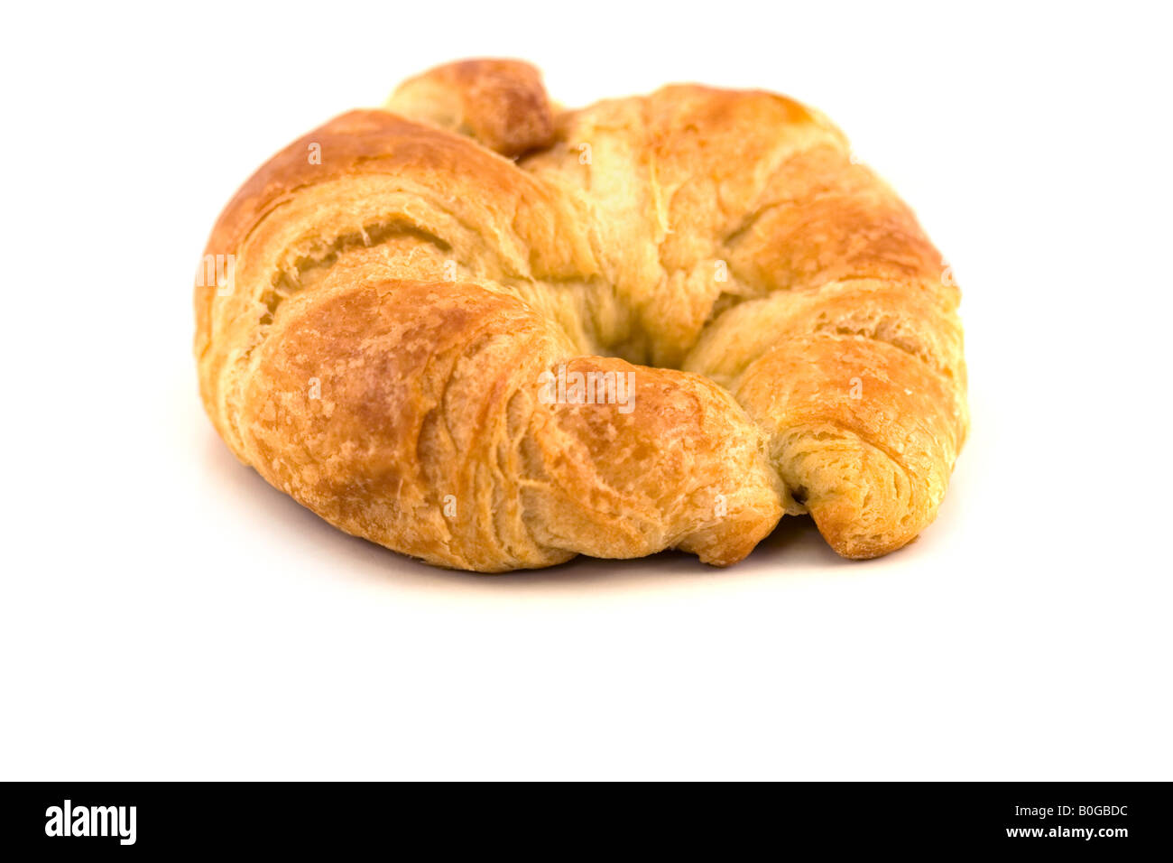 A round, golden croissant, isolated on a clean white background Stock ...