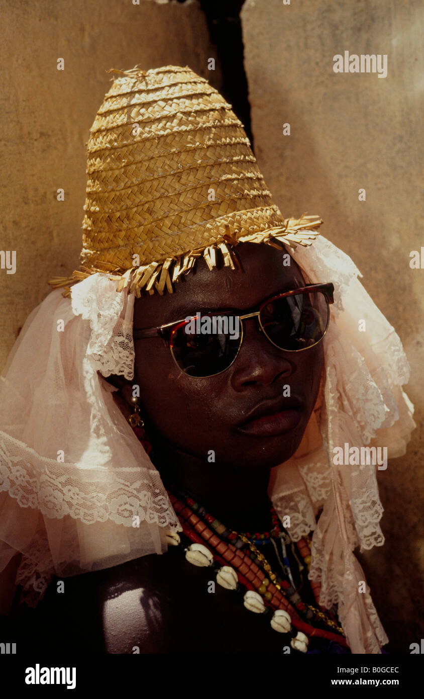 A Voodoo believer in ritual clothing at a temple ceremony, Ouidah ...