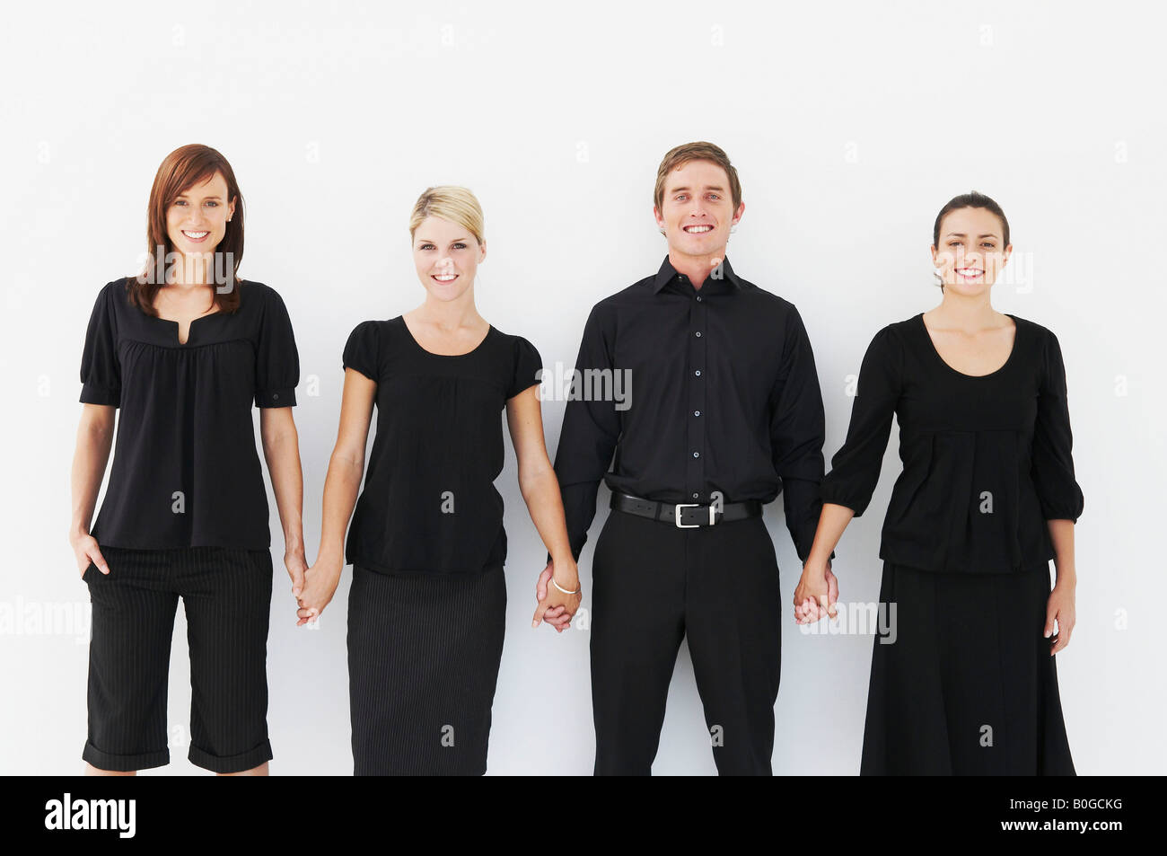 Four business people holding hands Stock Photo - Alamy