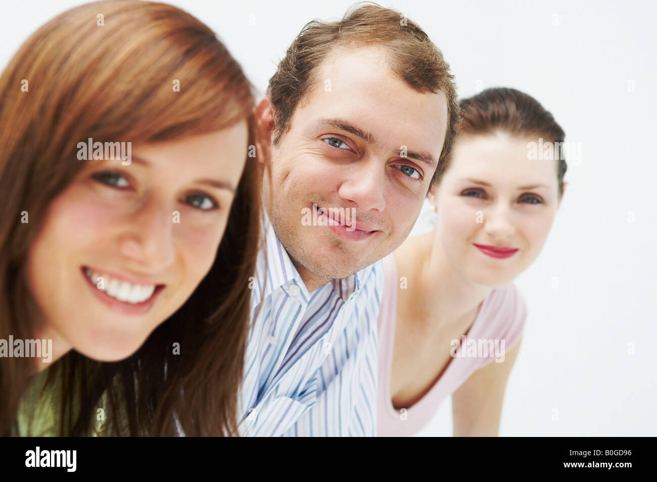 Three happy people, looking at camera Stock Photo - Alamy