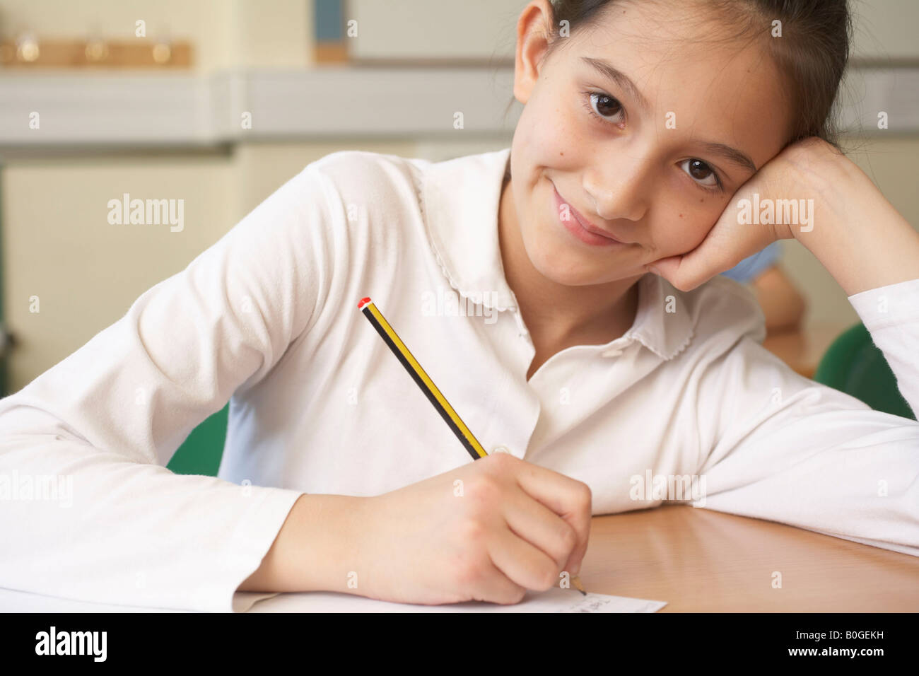Girl writing in classroom Stock Photo - Alamy