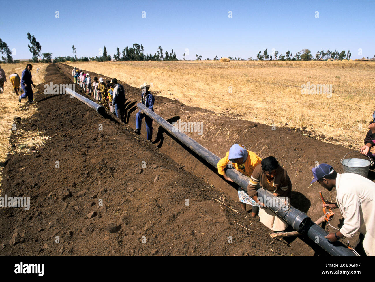 Water supply community and technical trainees digging a trench for a ...