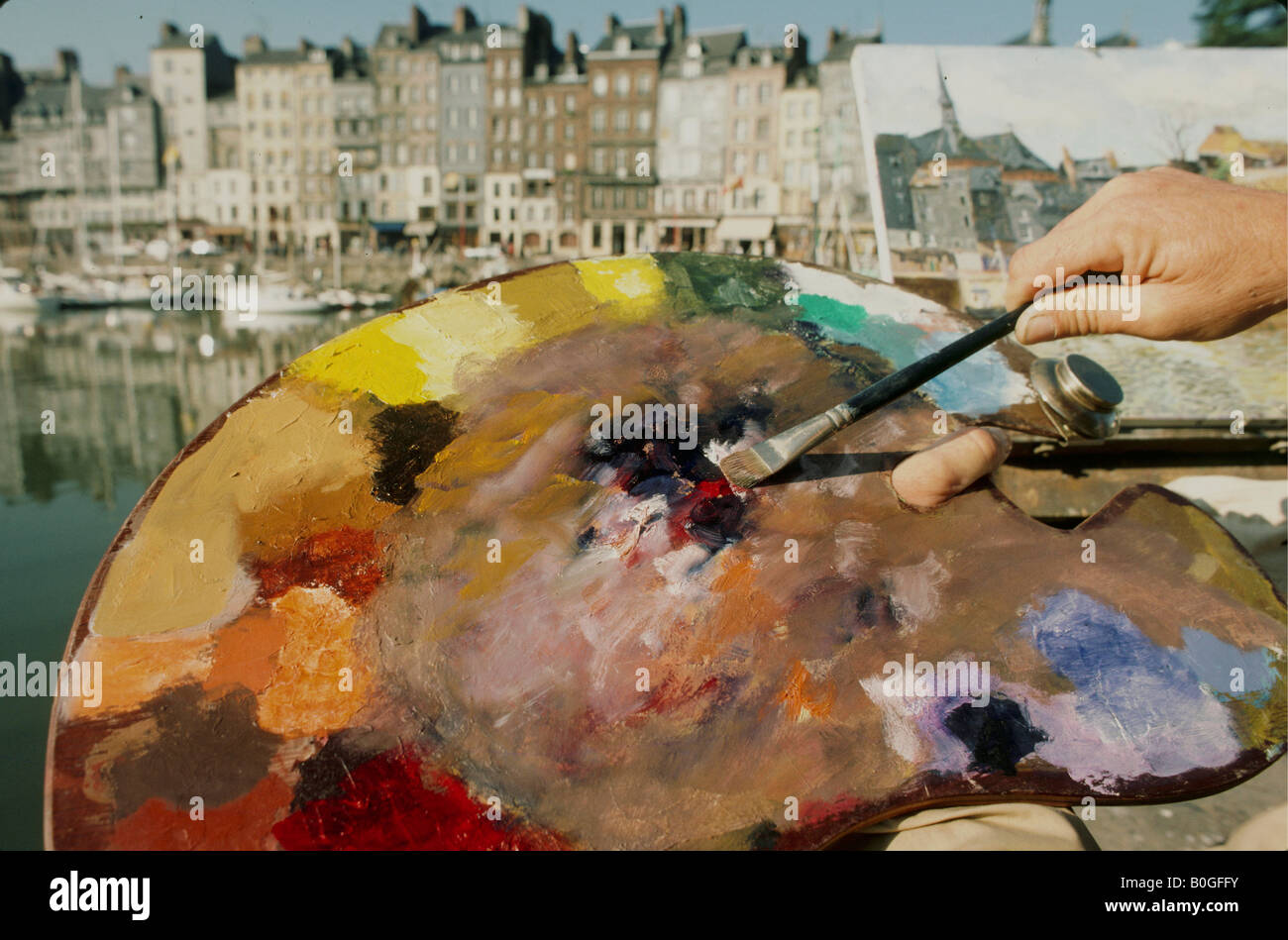 An artist painting the harbour, close-up of hand, Honfleur, France ...