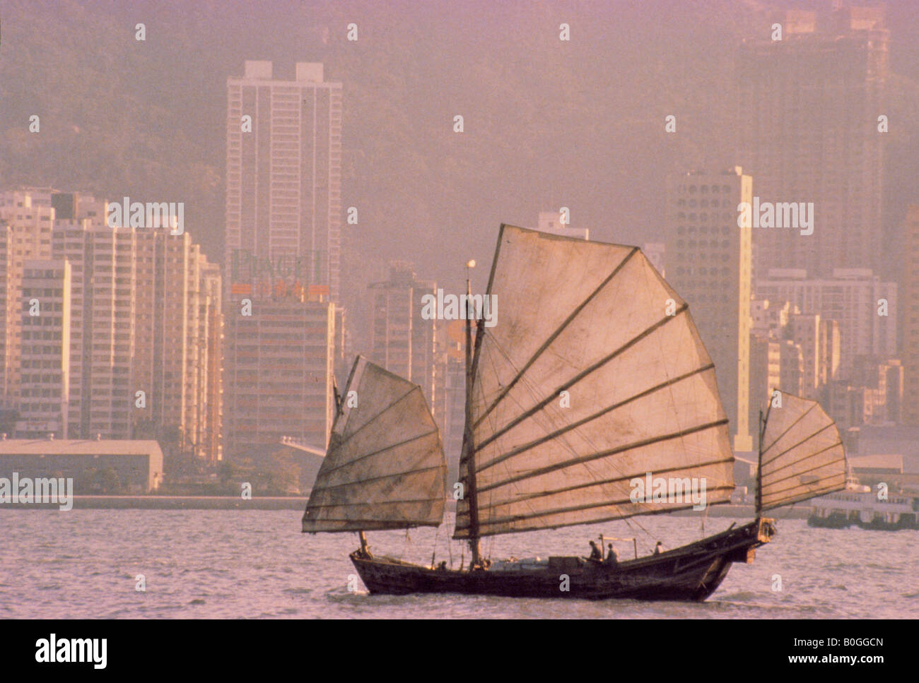 A Chinese junk sailing against the skyline of Hong Kong, China Stock ...