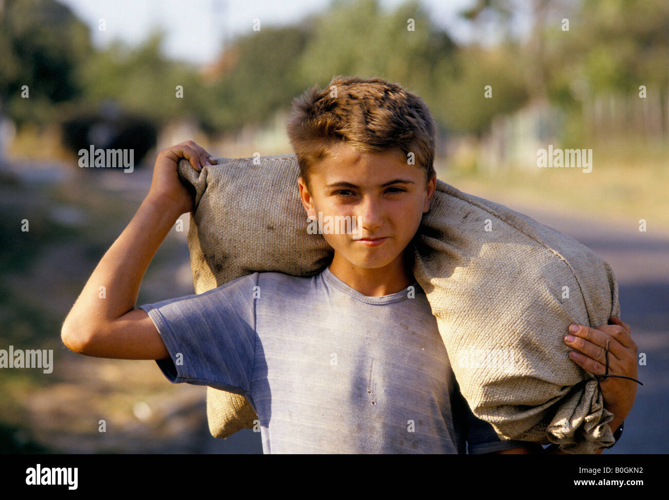 A boy carrying a sack across his shoulders, Romania Stock Photo - Alamy