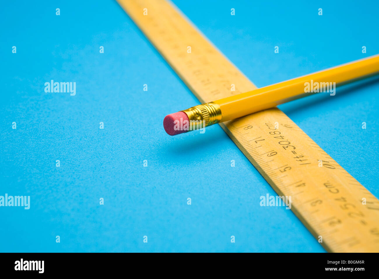 Yellow wooden ruler and pencil on blue background Stock Photo - Alamy