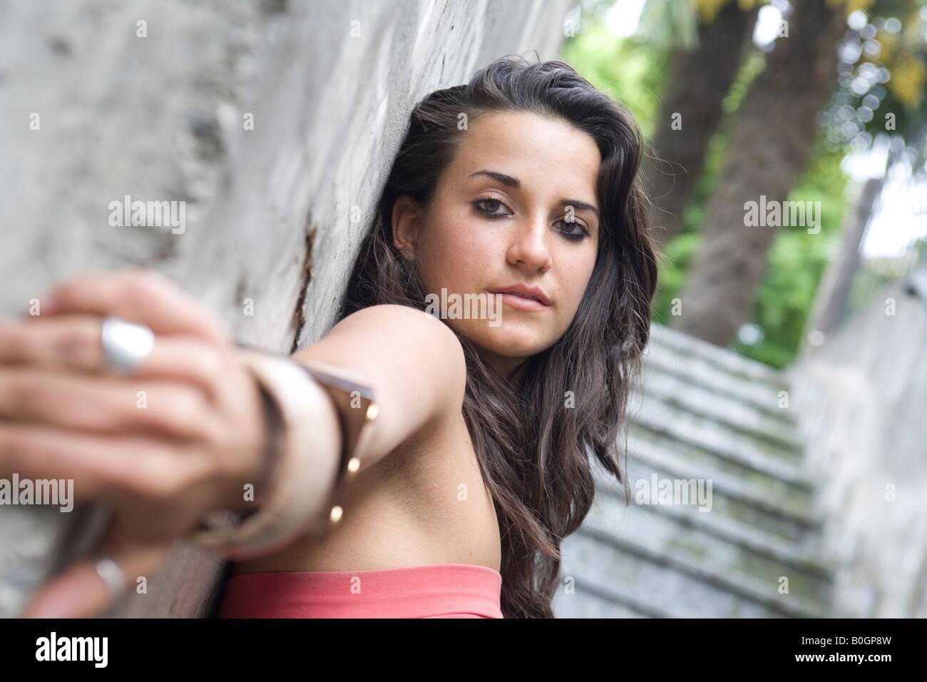 Young woman hiding herself behind a concrete wall Stock Photo - Alamy