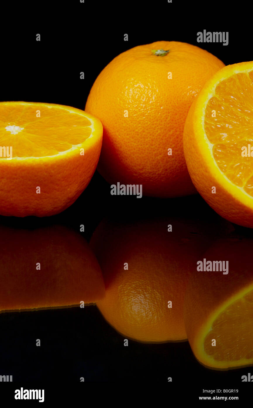 Oranges isolated against a black background Stock Photo - Alamy