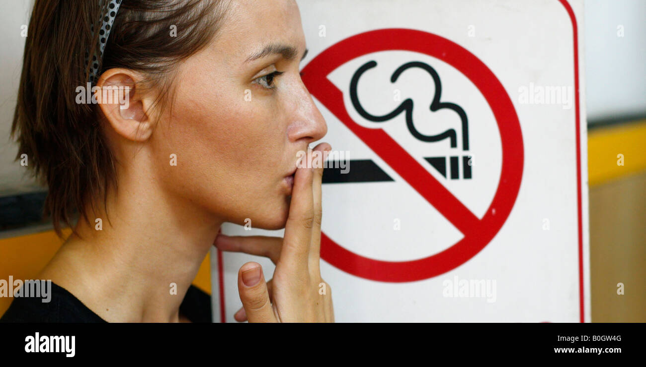 Lady smoking a non smoking panel Stock Photo - Alamy