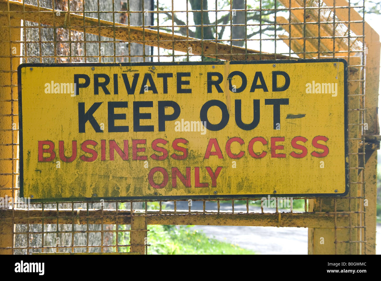 Yellow sign on fence/gate warning visitors to keep out Stock Photo - Alamy