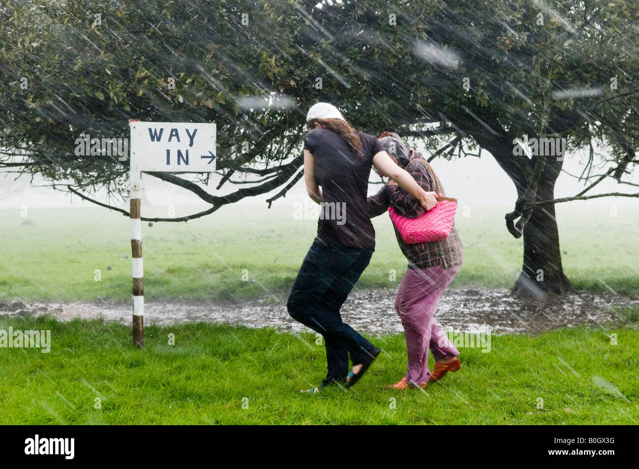 Two people running for shelter in a hail storm Stock Photo - Alamy