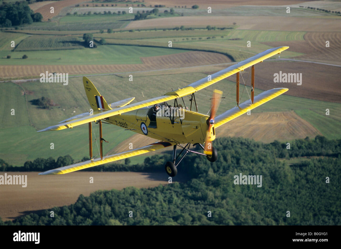 Old British trainer biplane De Havilland DH-82c Tiger Moth in flight ...