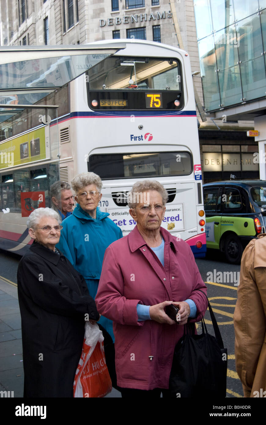 Elderly bus riders waiting at a bus stop, Glasgow, Scotland, United ...