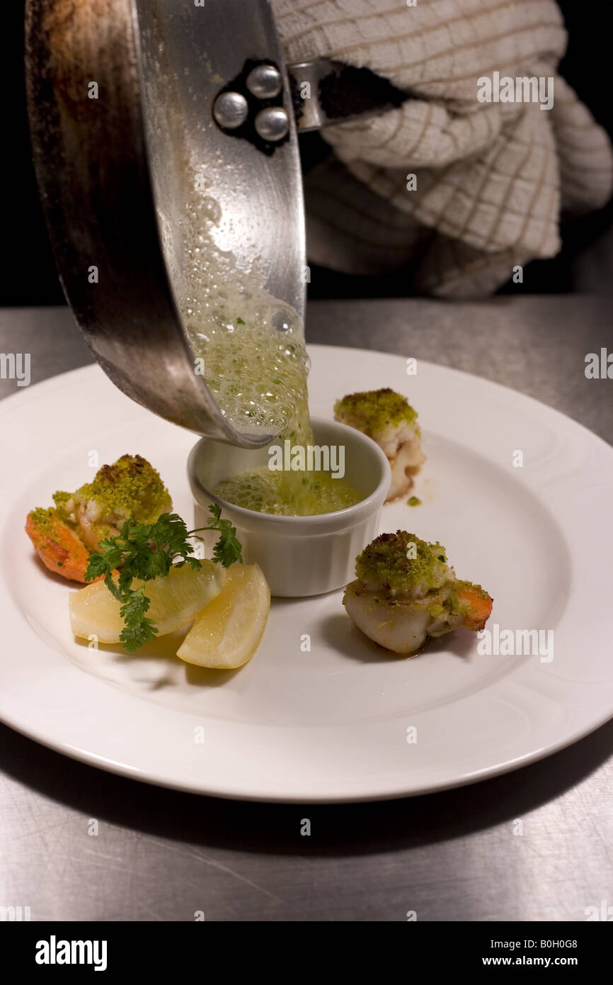 chef pouring garlic butter onto scallops Stock Photo - Alamy