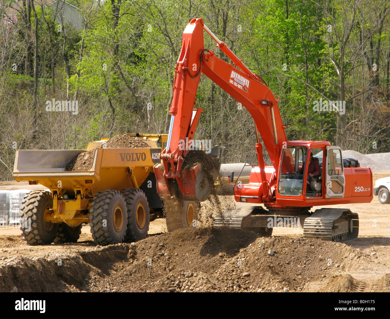Excavator loading hauler with dirt Stock Photo - Alamy