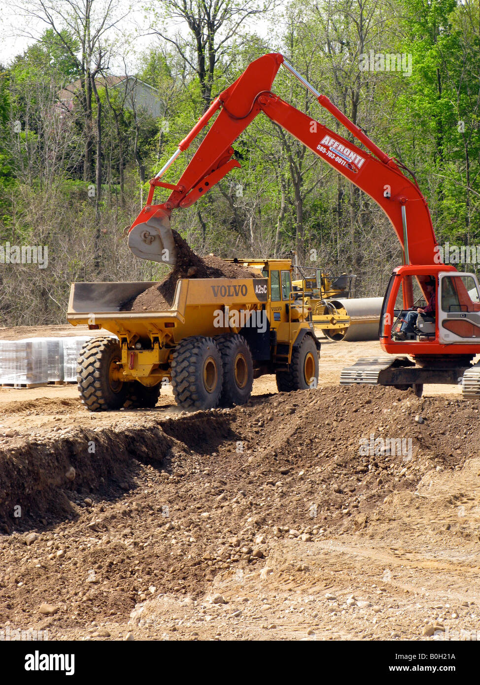 Excavator filling truck with dug up dirt Stock Photo - Alamy