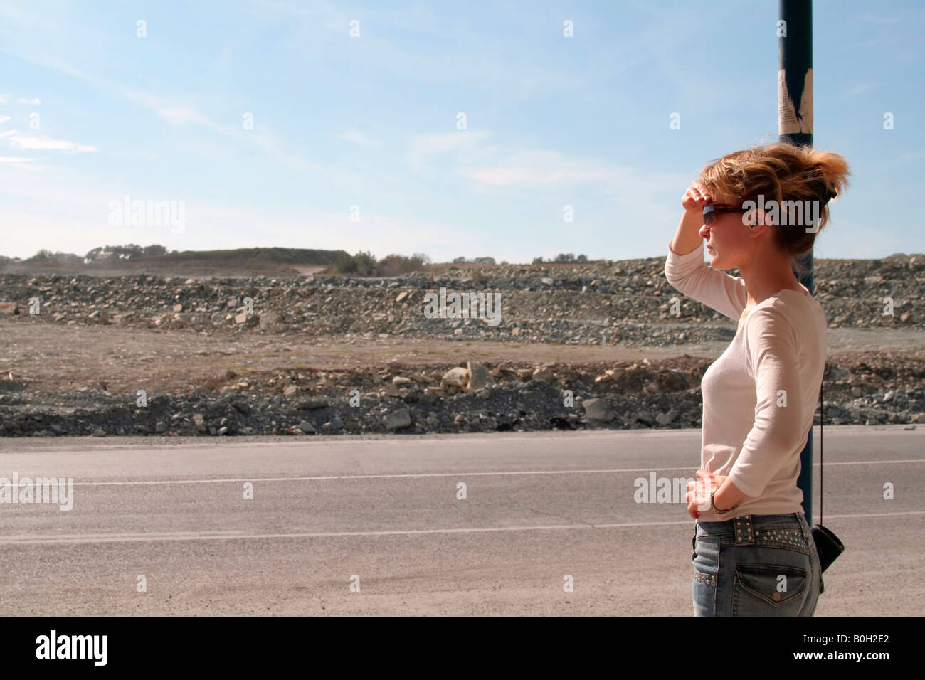 woman standing alone by deserted road Stock Photo - Alamy