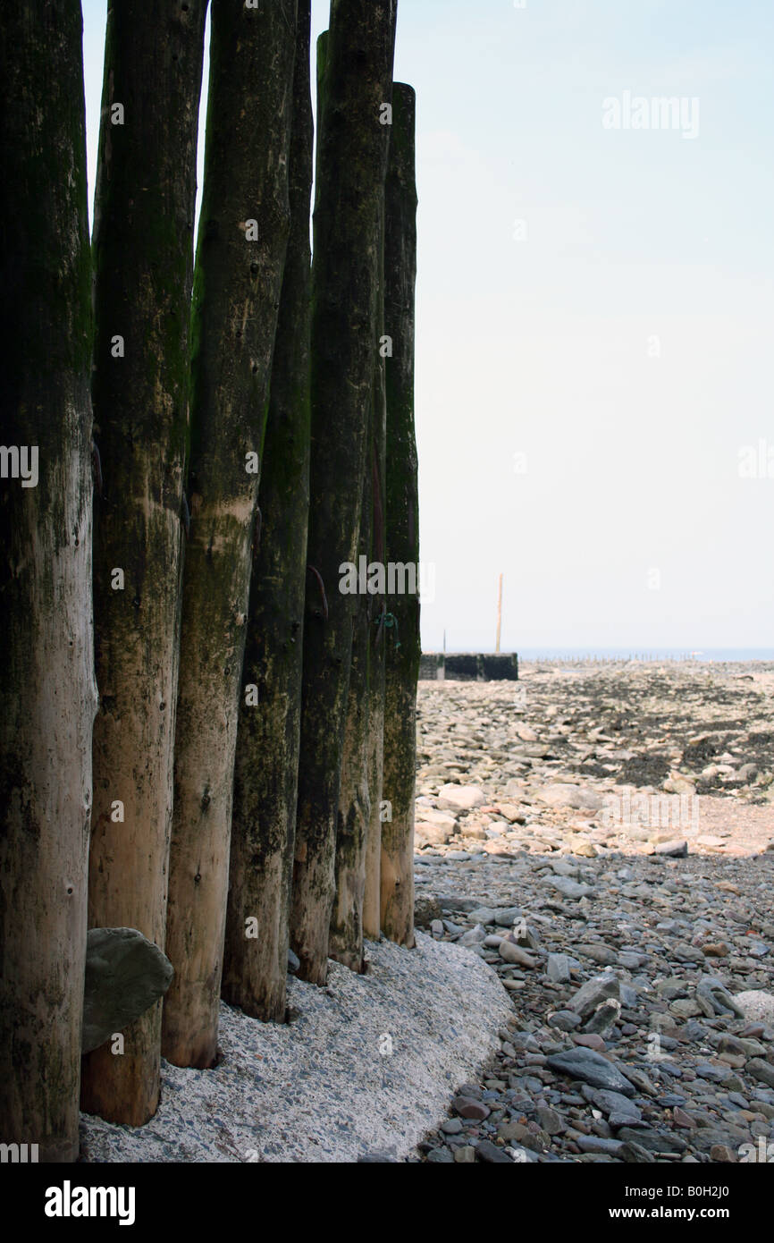 Wooden posts at mouth of an empty Lynmouth harbour looking out to sea ...