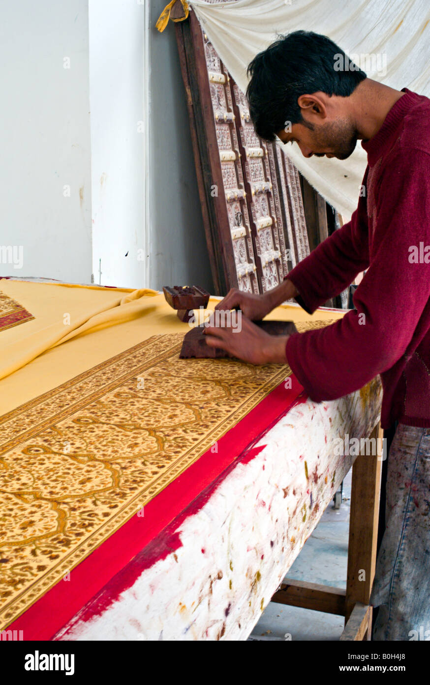 INDIA JAIPUR Young Indian craftsman using a carved wooden block to make ...