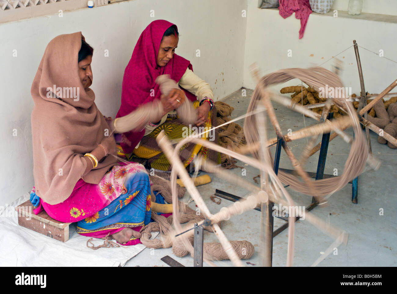 INDIA JAIPUR Indian women in colorful saris skein wool yarn that will ...