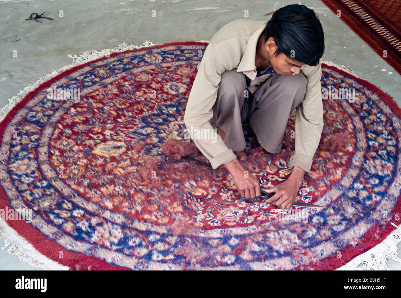 INDIA JAIPUR Young Indian craftsman using scissors to trim the fuzz ...