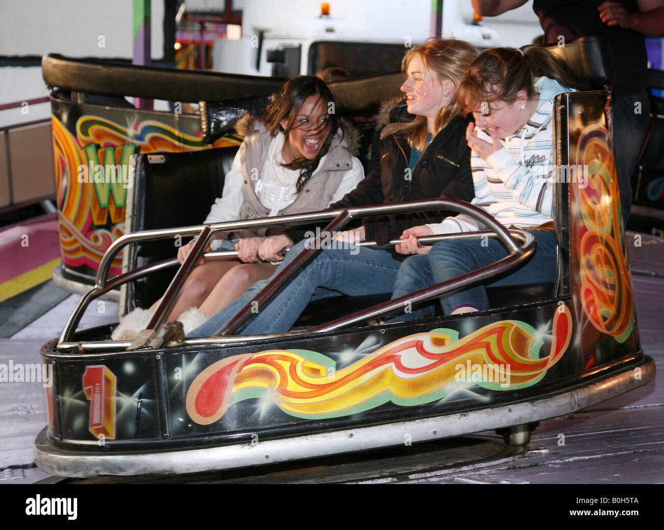 Three teen girls enjoying the rides at the funfair, the fairground ...