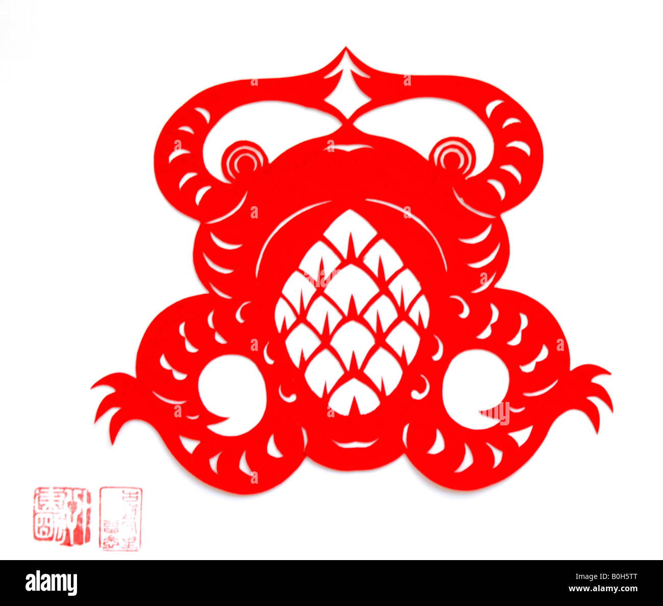 Frog papercut made by using scissors to cut out image freehand from red ...