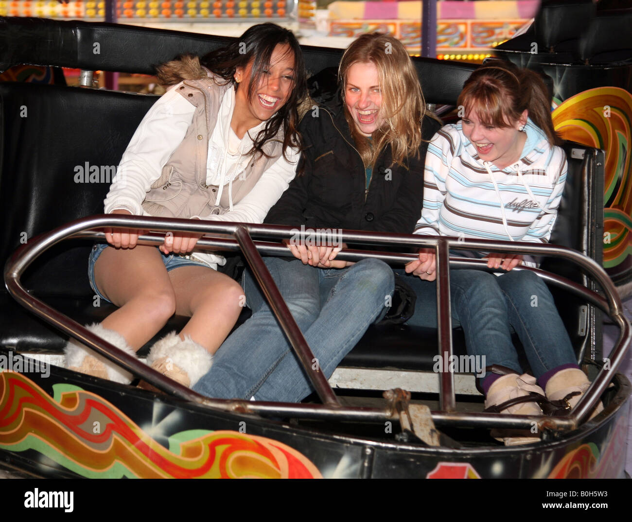 Fun Fair UK; Three girls enjoy a ride at the fairground funfair ...